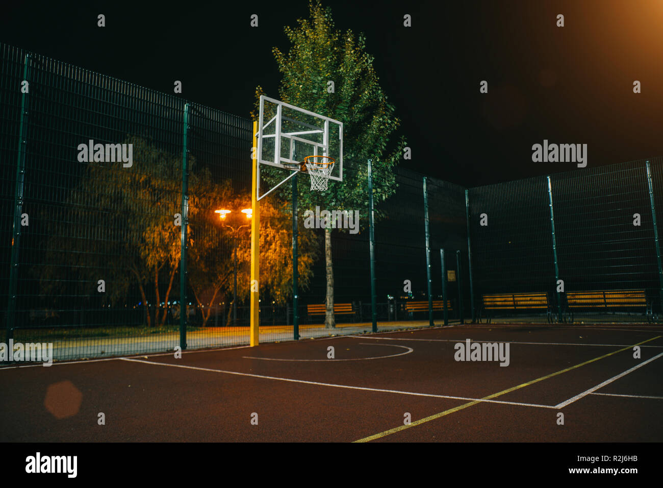 Illuminated basketball playground with red pavement, modern new ...