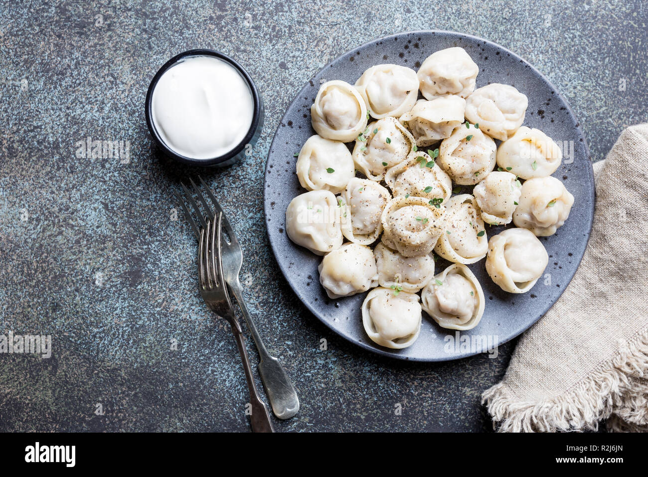 Traditional homemade Russian pelmeni meat dumplings with sour cream and ...