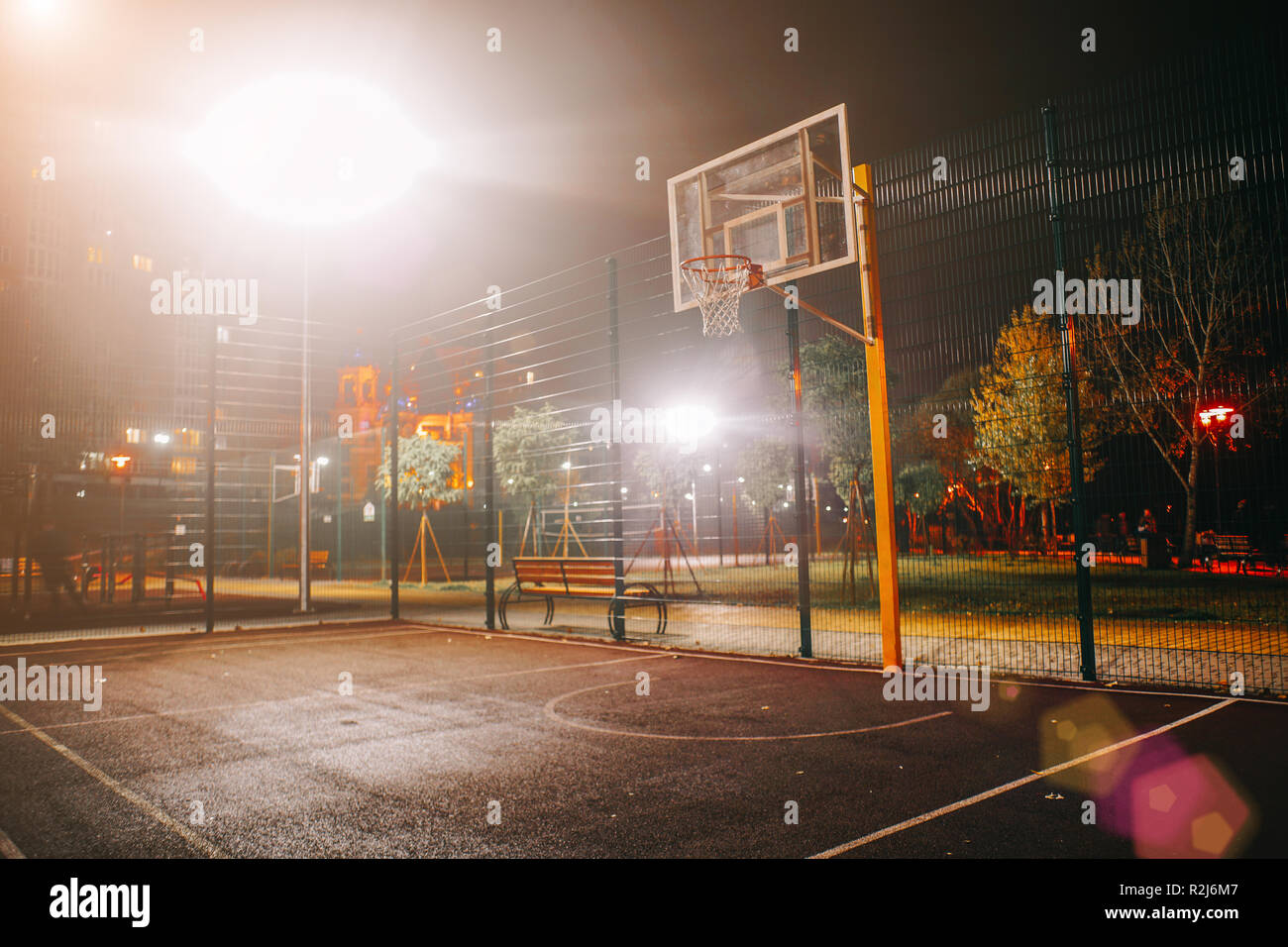 Illuminated basketball playground with red pavement, modern new ...