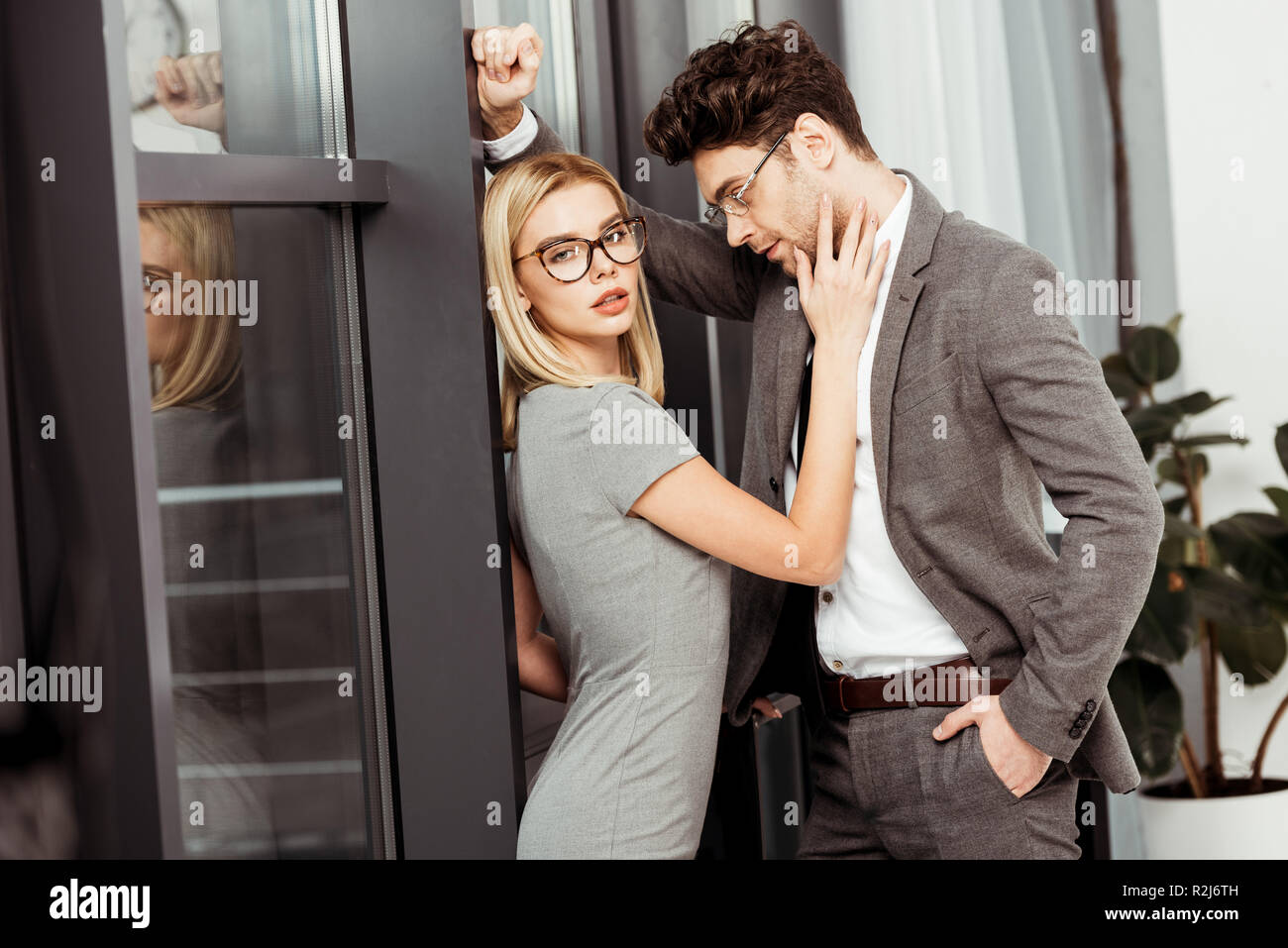 side view of businesspeople flirting in office, office romance concept ...