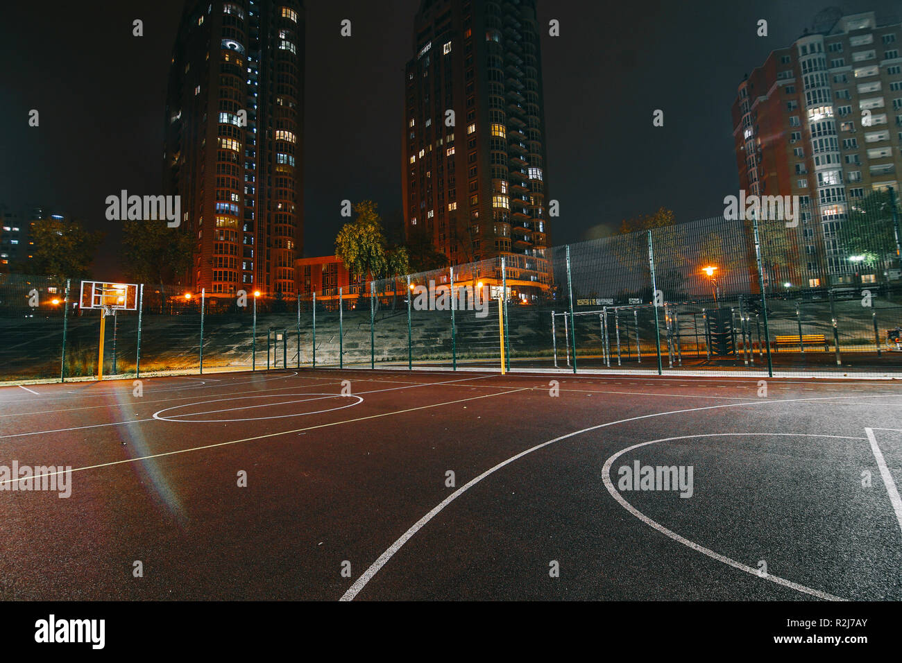 Illuminated basketball playground with red pavement, modern new ...