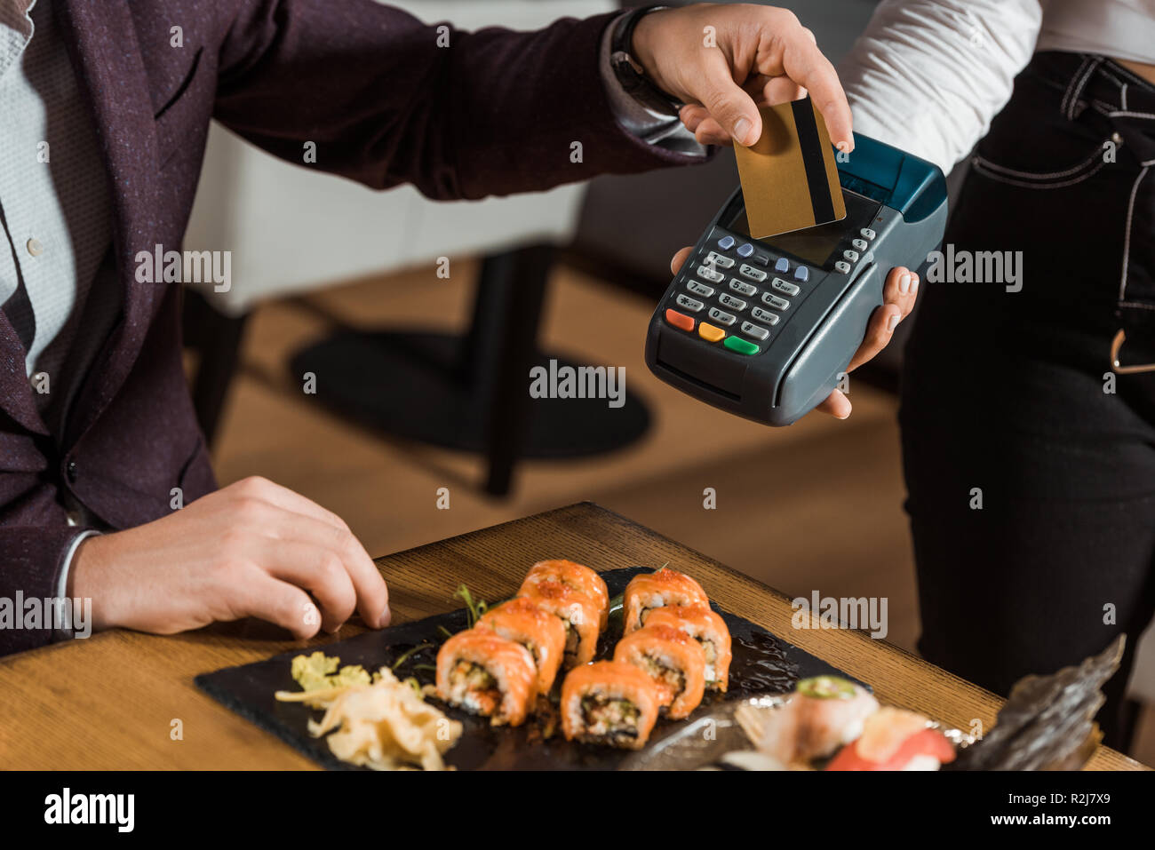 Partial view of man paying by credit card for dinner in restaurant ...