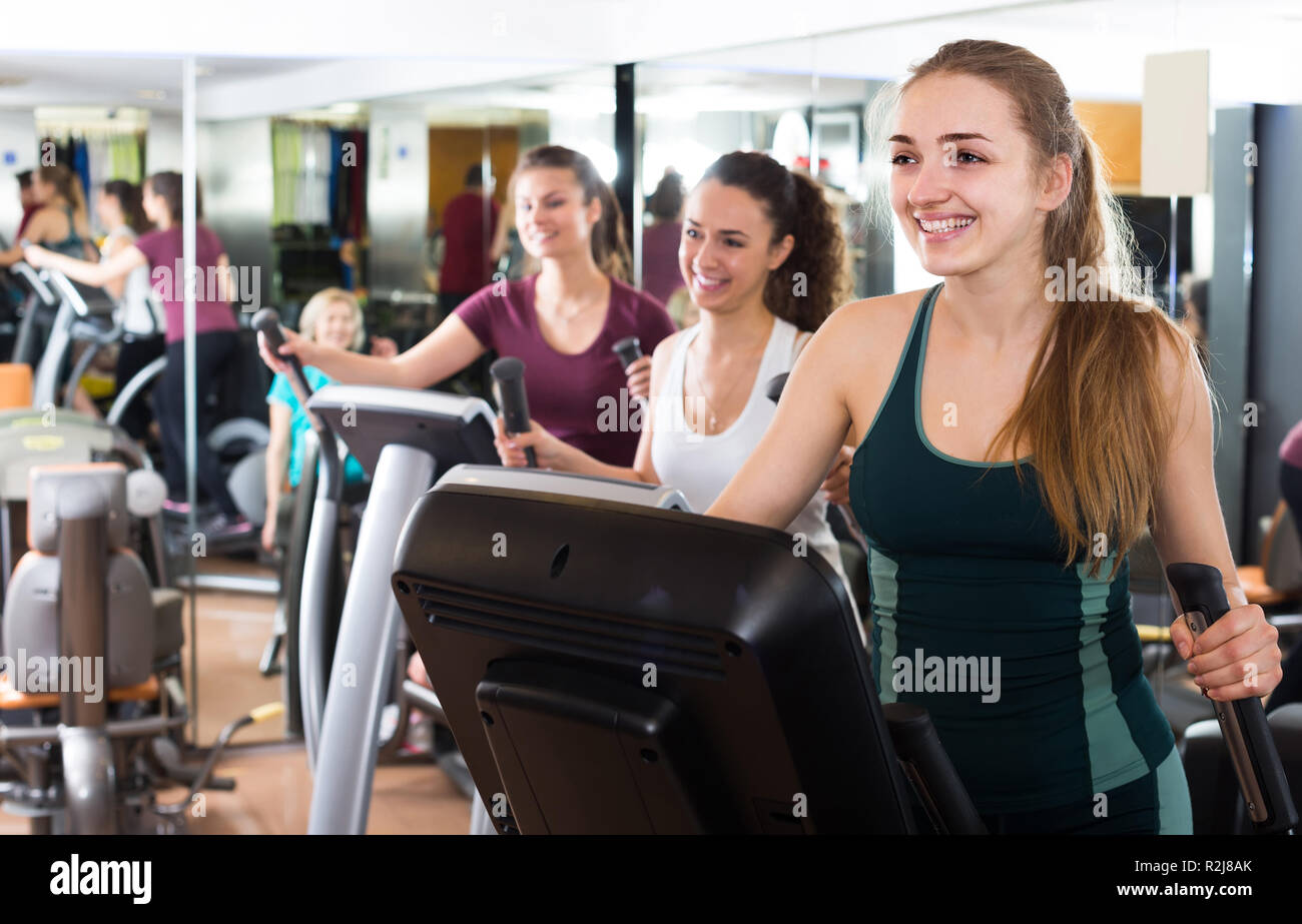 Positive russian females training on elliptical trainers in fitness ...