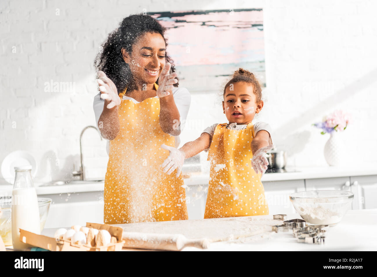 smiling african american mother and daughter preparing dough and having ...