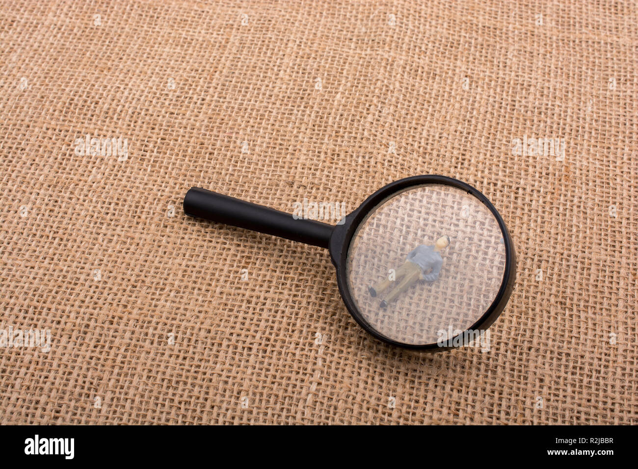 Tiny figurine of man miniature model under magnifying glass Stock Photo ...