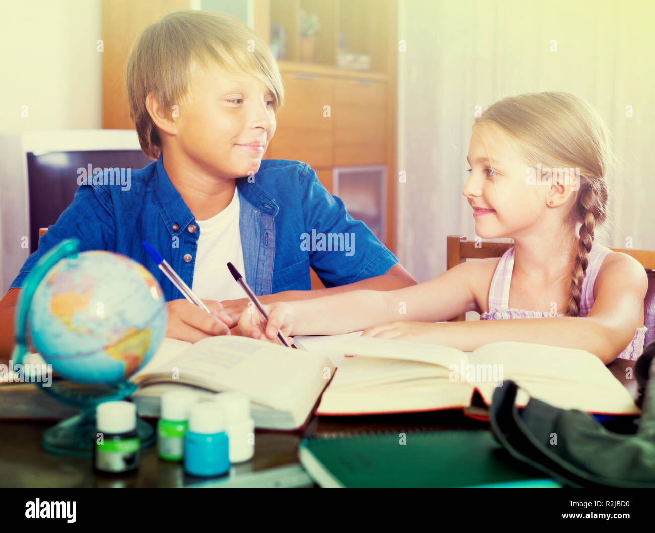 Smiling siblings kids doing homework with books at home Stock Photo - Alamy