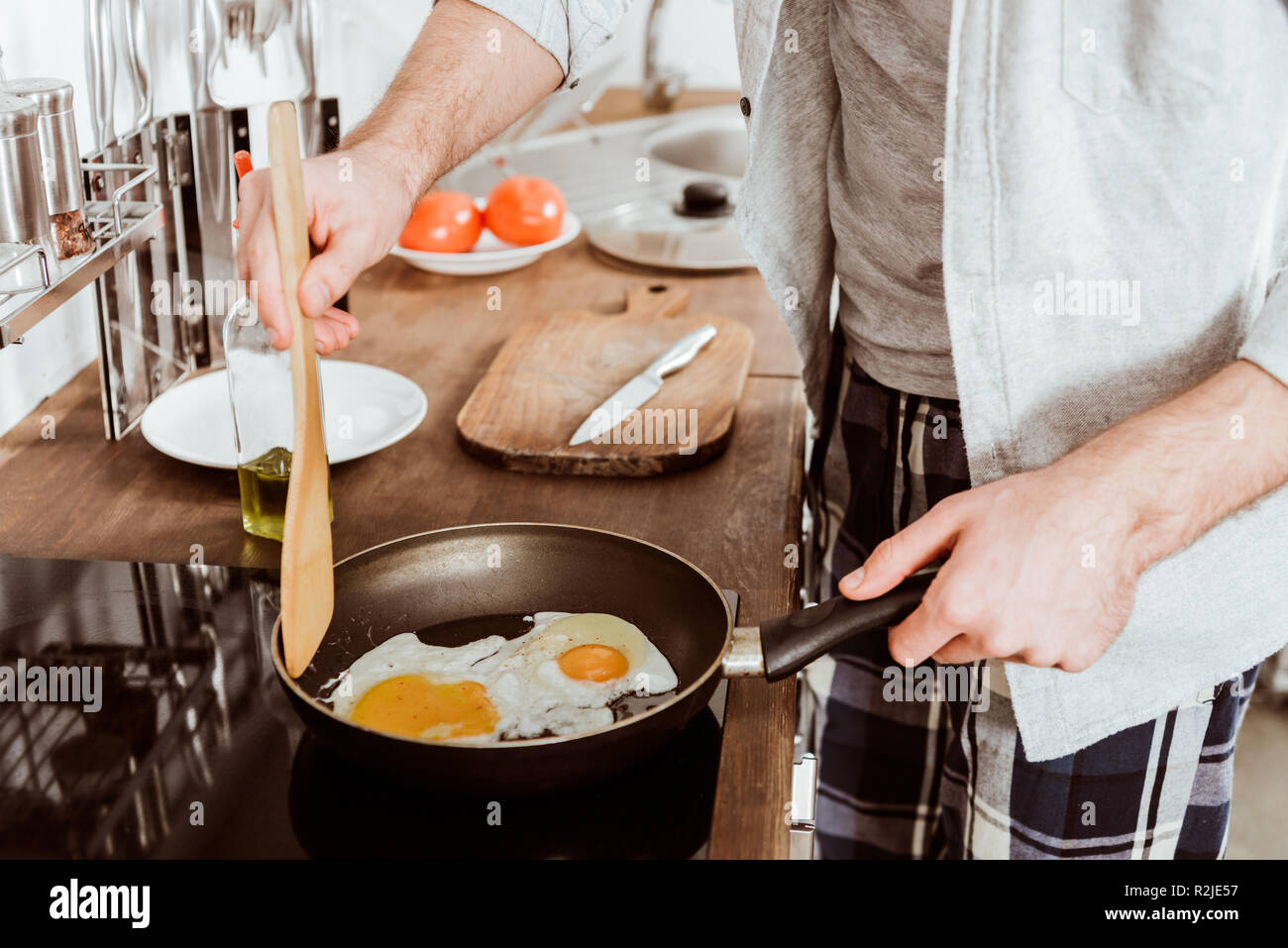 Young man cooking eggs hi-res stock photography and images - Alamy