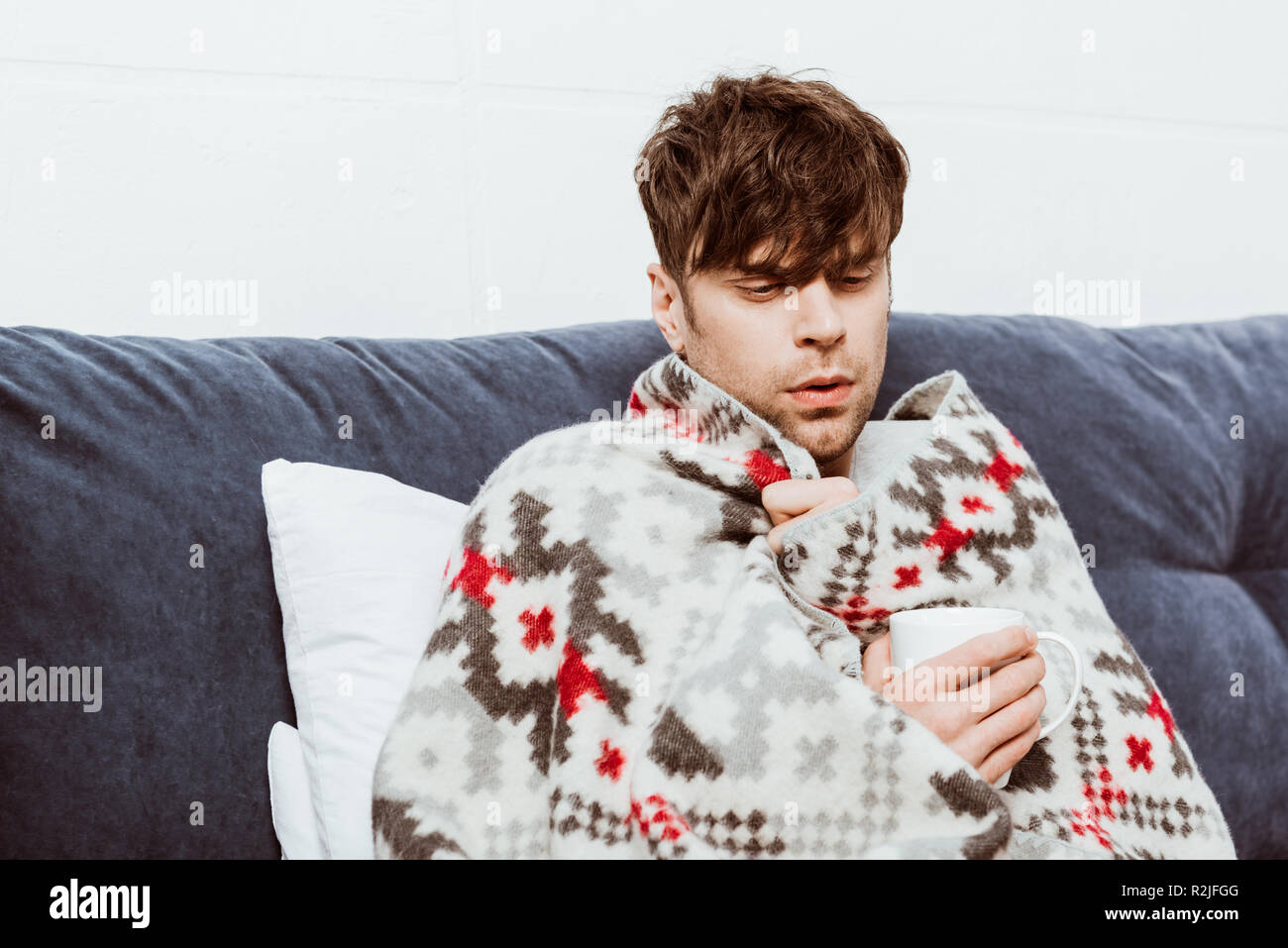Sick male wrapped in blanket hi-res stock photography and images - Alamy