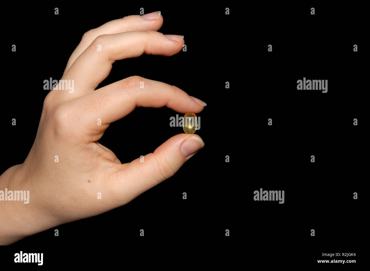 pill in hand isolated on black Stock Photo - Alamy