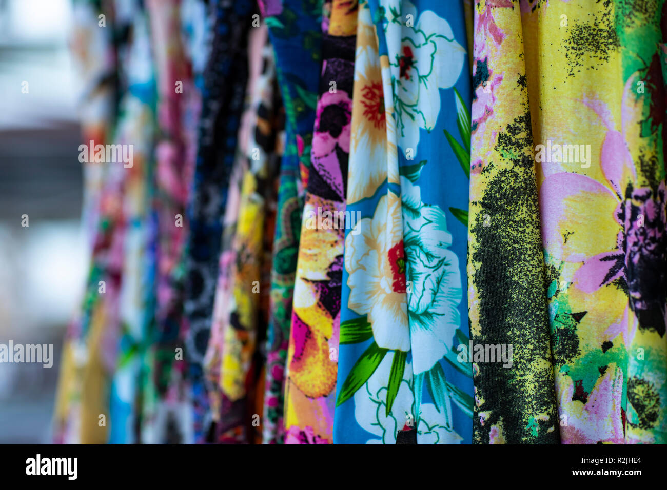 Colorful fabrics hanging and lined. Fabrics with different patterns and ...