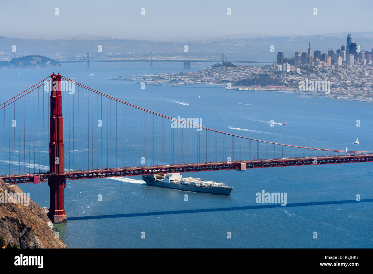 Cargo ship passing under Golden Gate Bridge on a sunny day; San ...