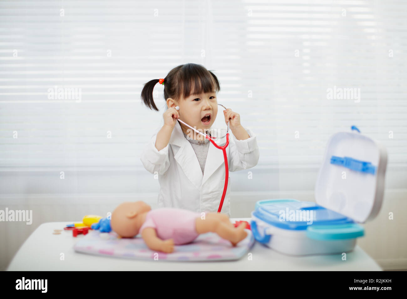 Toddler baby girl pretend playing as doctor at home Stock Photo - Alamy