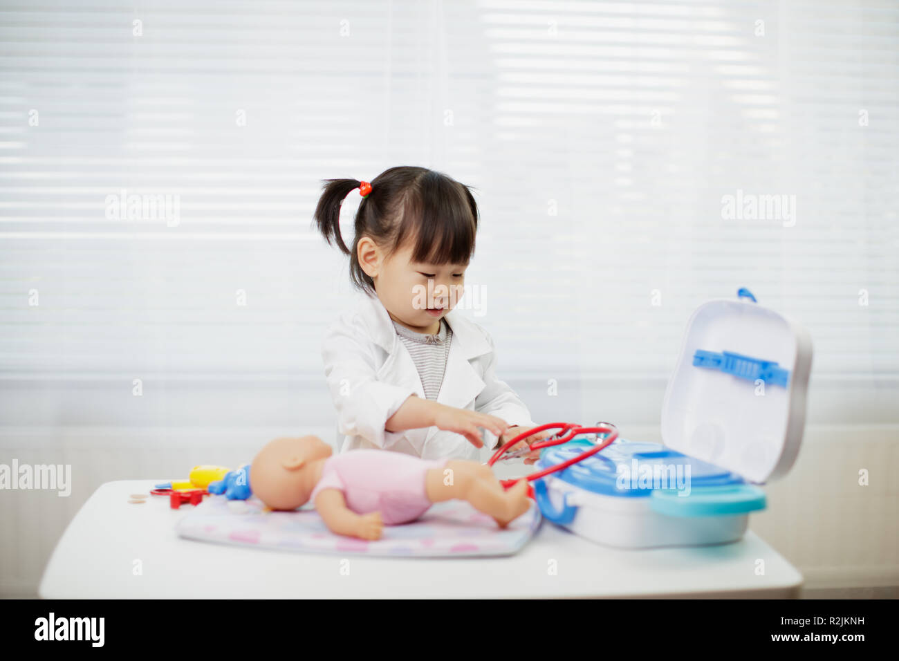 Toddler baby girl pretend playing as doctor at home Stock Photo - Alamy
