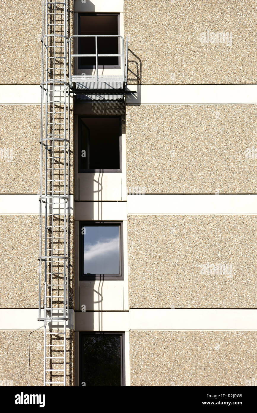 A fire escape on the side of a residential building casts a shadow ...