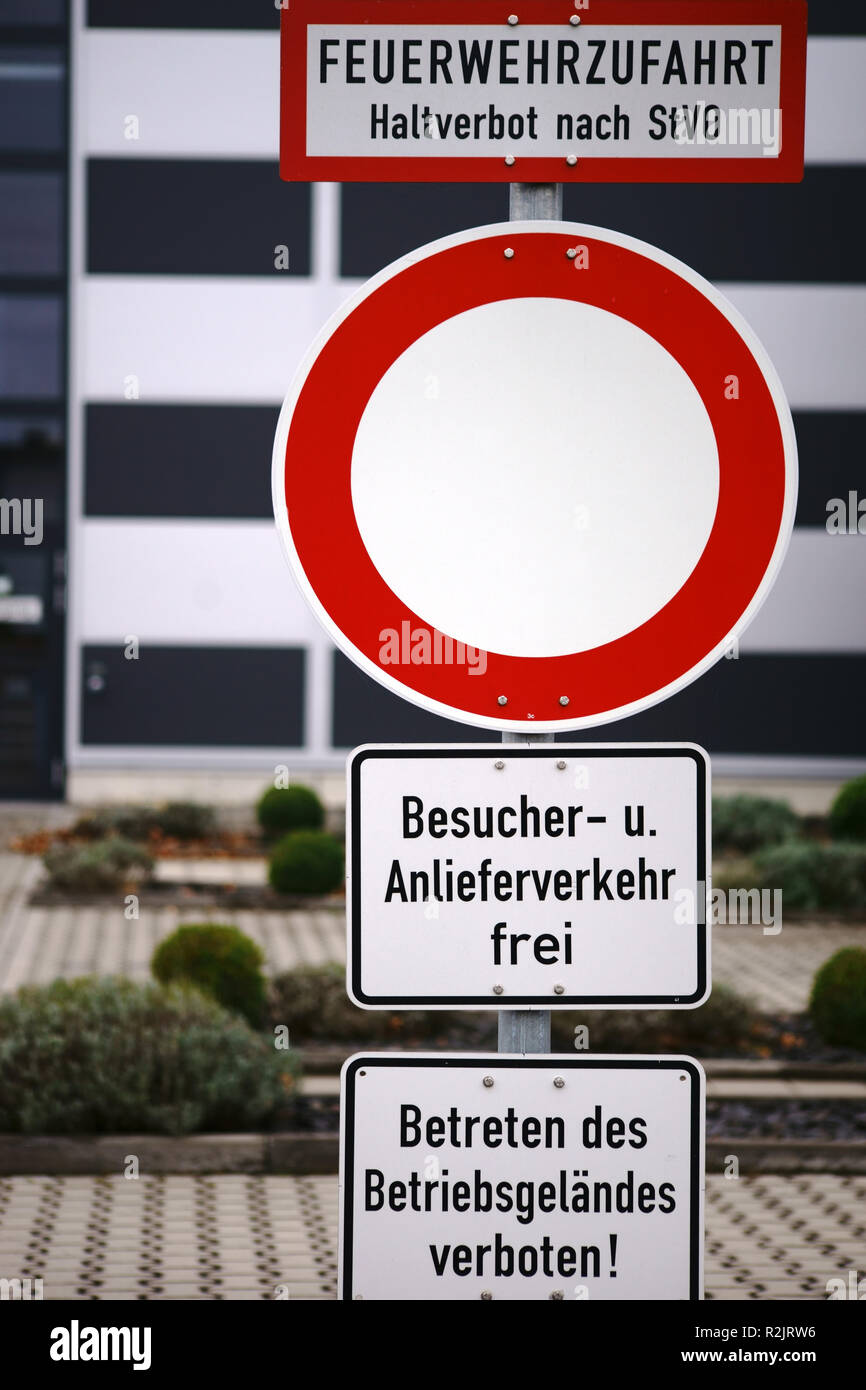 Many different road signs in front of the industrial site of a factory ...