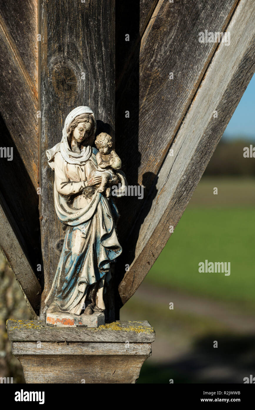 weathered Virgin Mary figure with child at a wayside cross, Upper ...