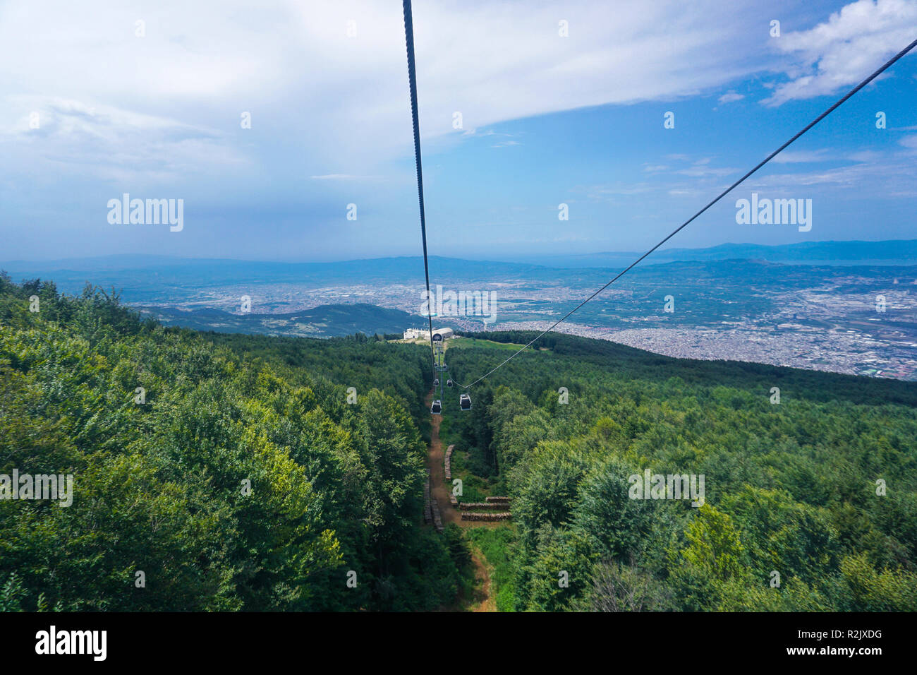 Cable cars going up in to the mountain, green hills Stock Photo - Alamy