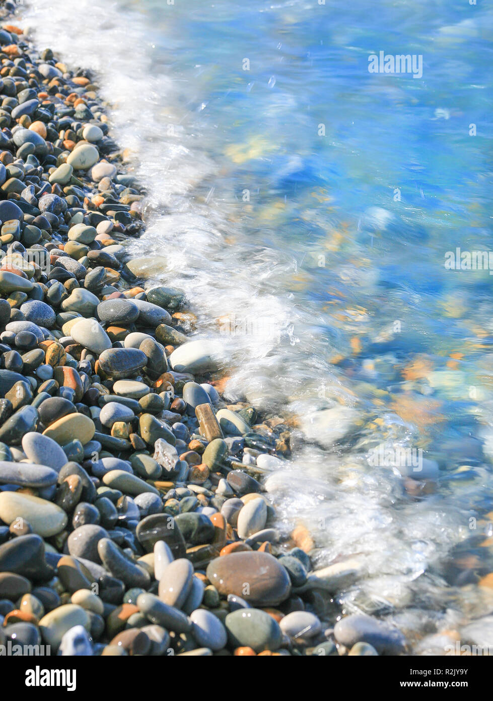 oval pebbles and wave on the beach closeup, background Stock Photo - Alamy