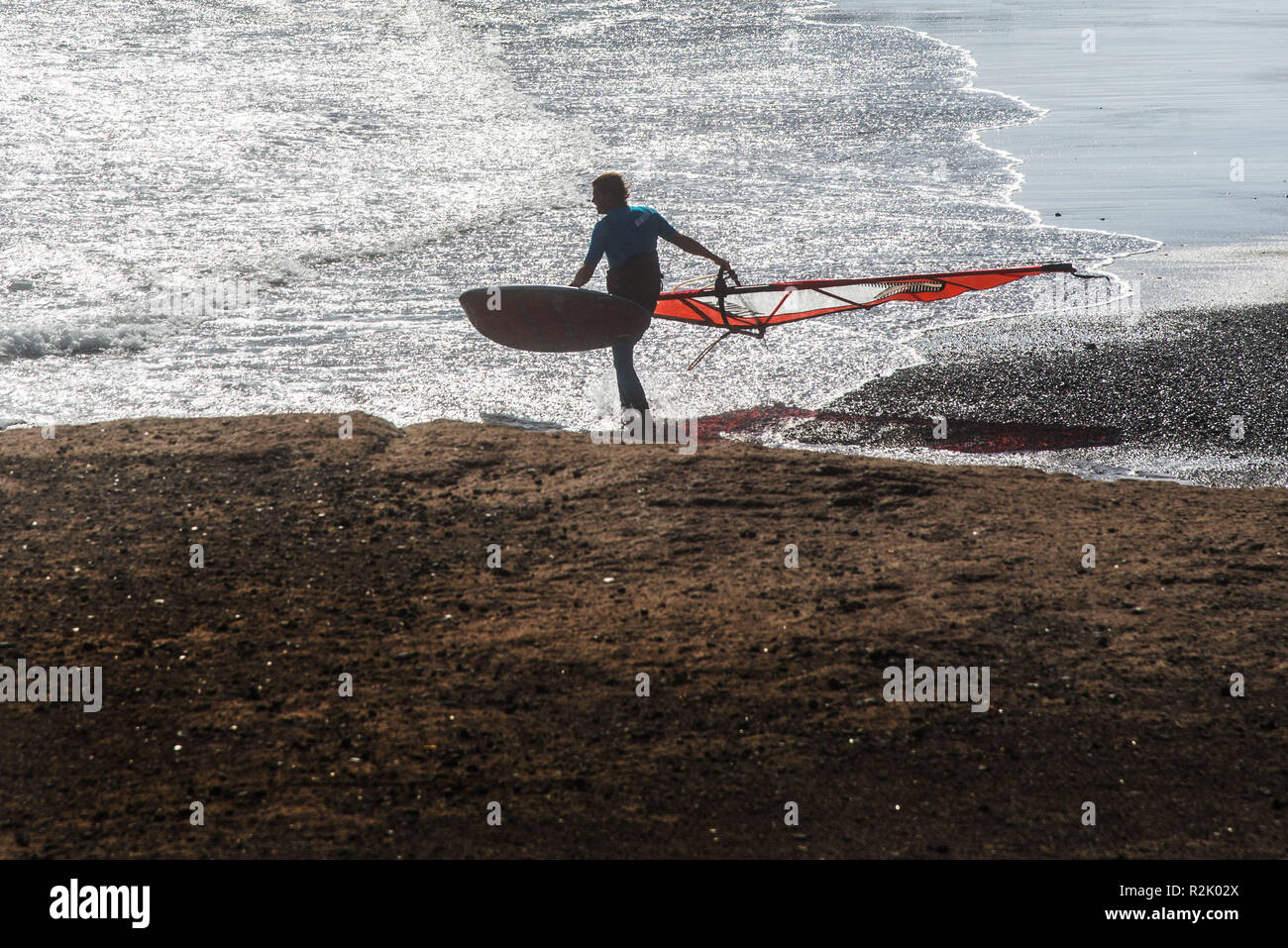 Windsurfer on the beach on the way to the water Stock Photo - Alamy