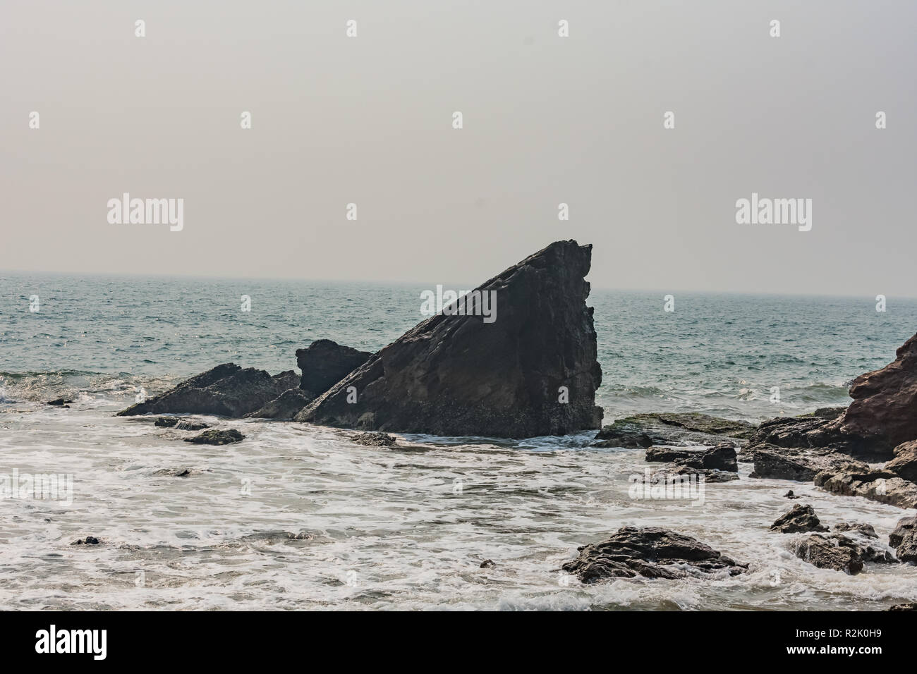 A beautiful and unusual rock in the sea, vertical, flat and high, next ...