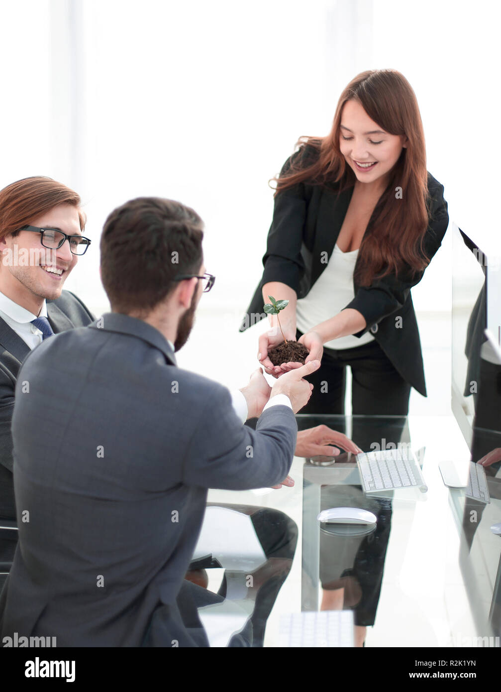 vertical photo.a happy employee is showing fresh sprout Stock Photo - Alamy
