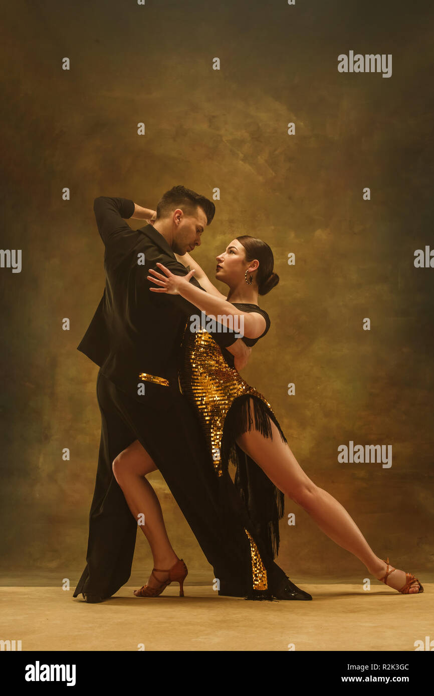 The young dance ballroom couple in gold dress dancing in sensual pose ...