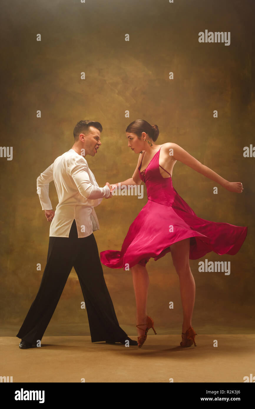 The young dance ballroom couple in gold dress dancing in sensual pose ...