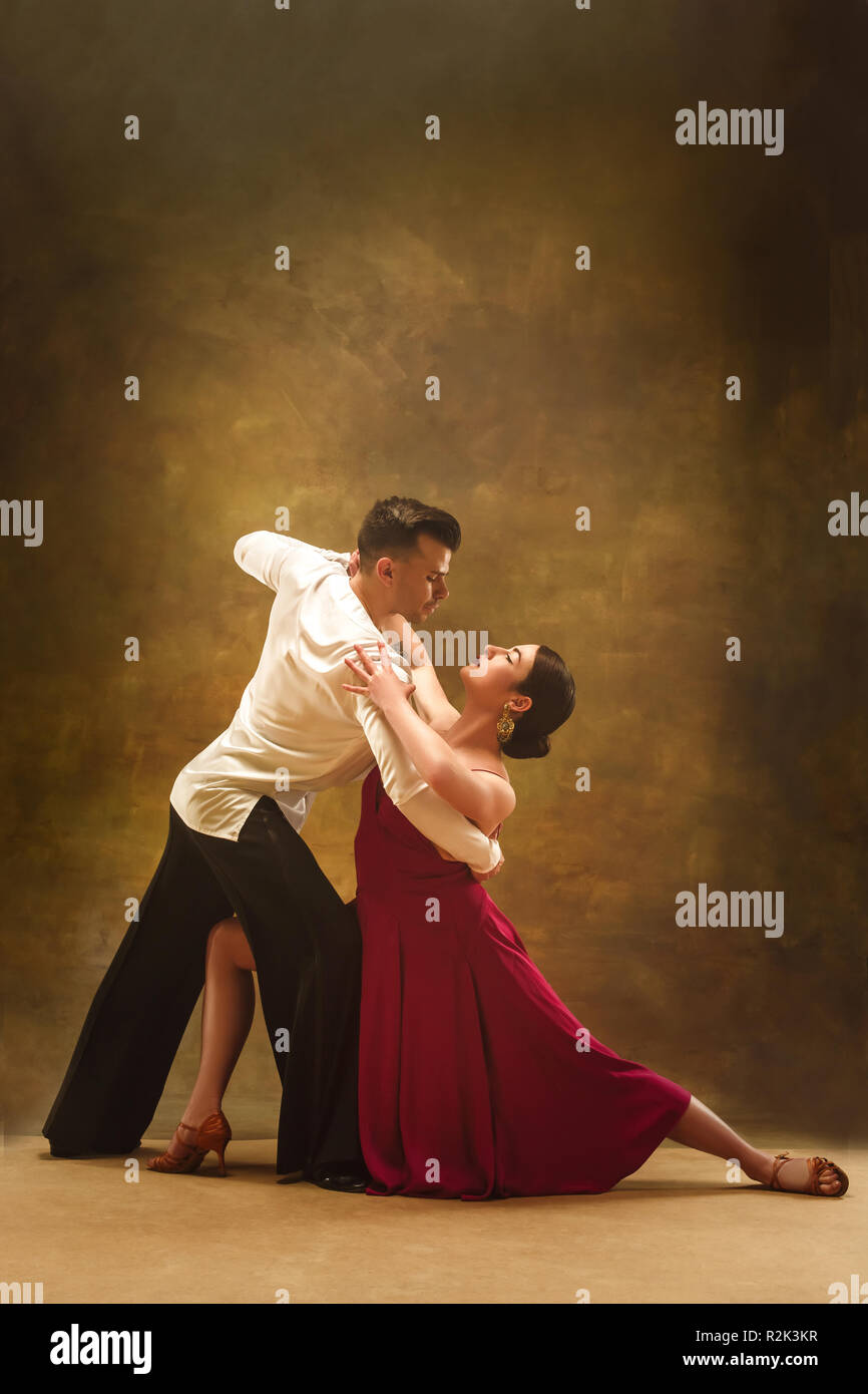 The young dance ballroom couple in gold dress dancing in sensual pose ...
