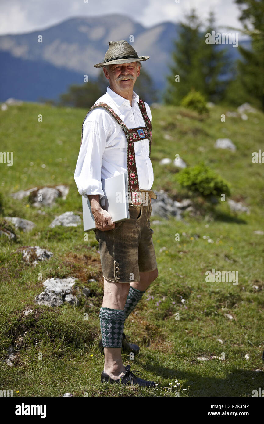 performer in traditional costume / 'Trachtler' with laptop, outside ...