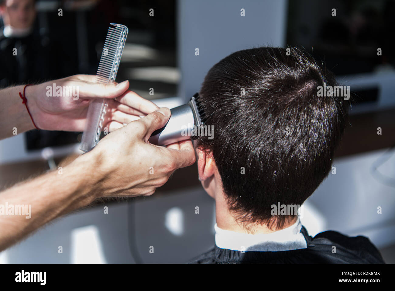Perfect trim. Rear view close-up of young man getting haircut by ...