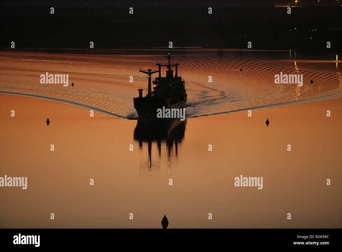 A small ship crousing during a sunset Stock Photo - Alamy