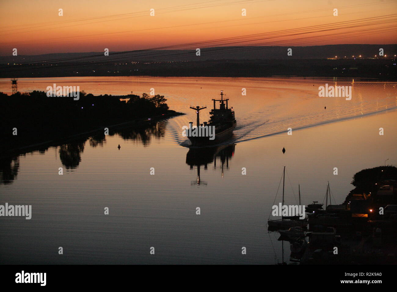 A small ship crousing during a sunset Stock Photo - Alamy