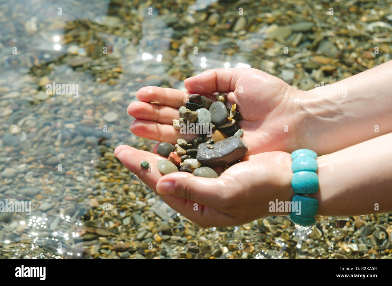 vacation concept of pebble in a hand Stock Photo - Alamy