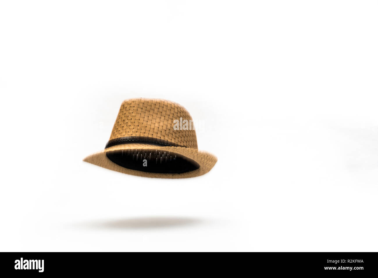 At the Drop of a Hat. A straw panama hat falling against a white ...