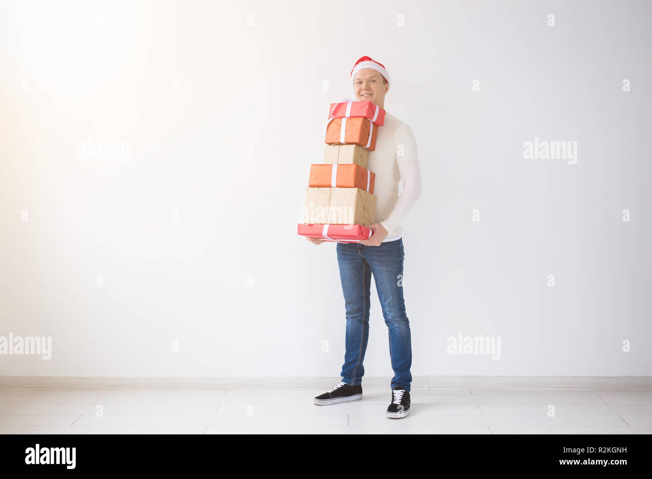 Christmas and holidays concept - Close up of man holding stack of gift ...