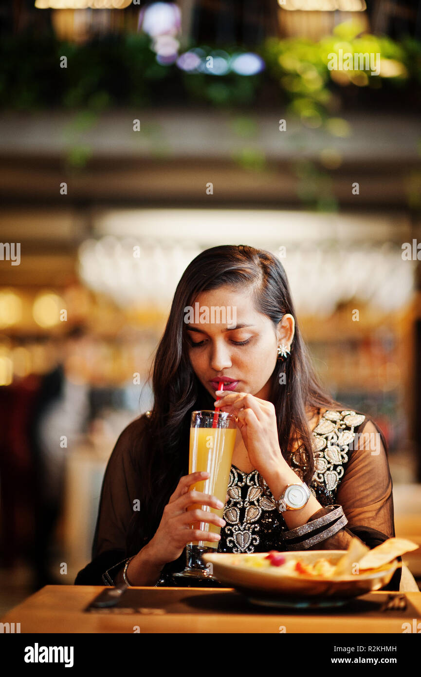 Pretty indian girl in black saree dress posed at restaurant, sitting at ...