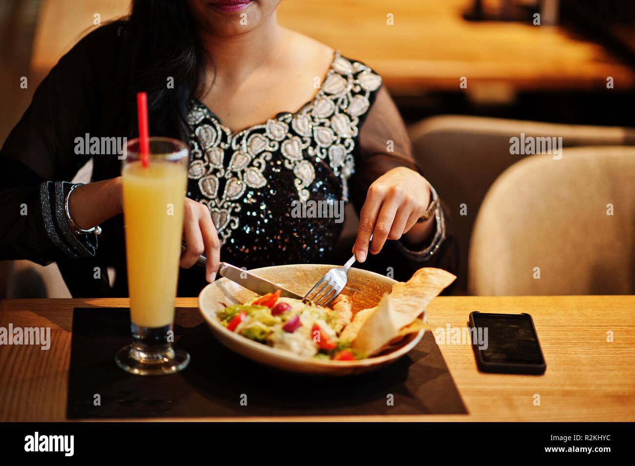 Pretty indian girl in black saree dress posed at restaurant, sitting at ...