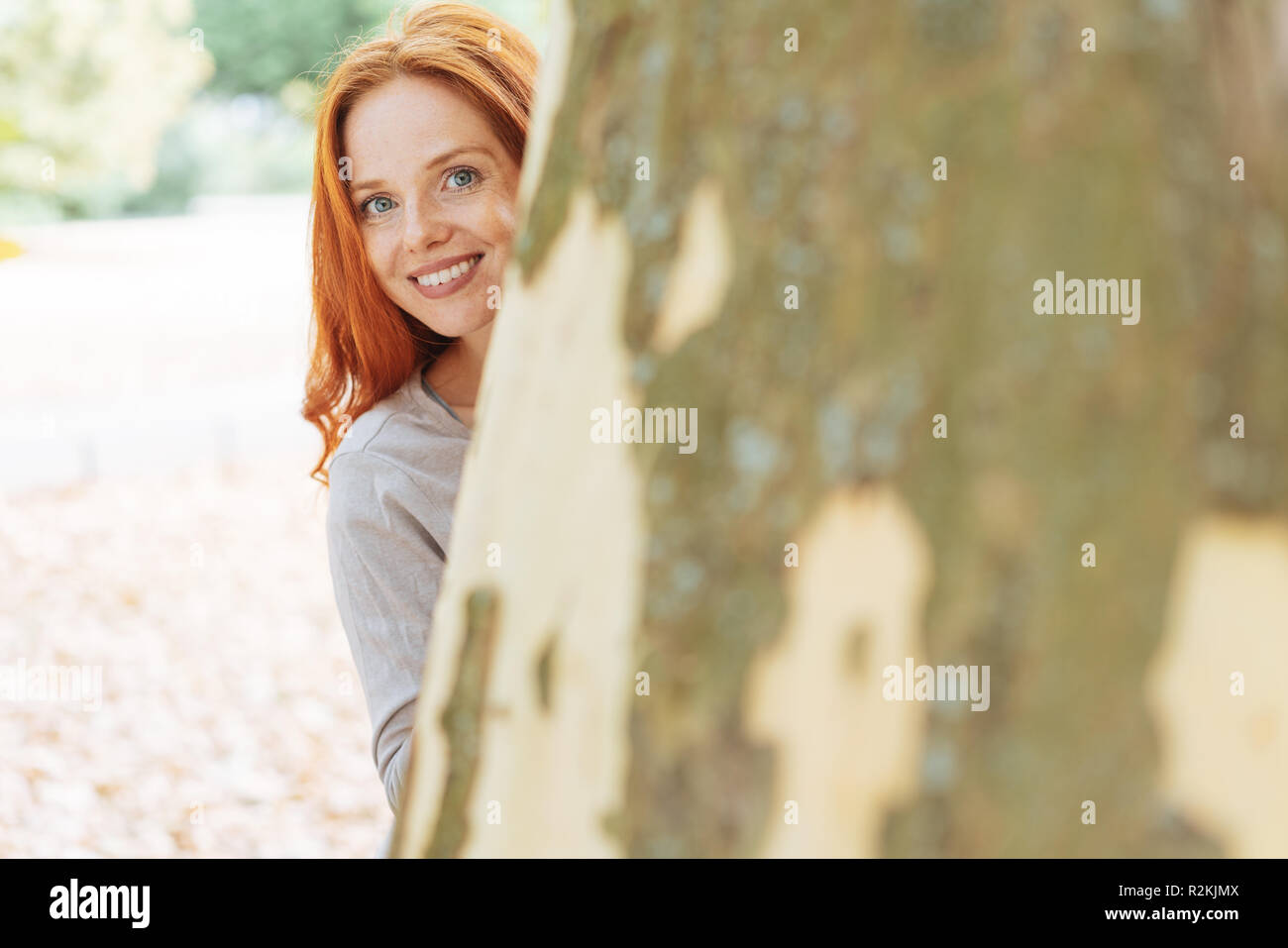 Woman peeking tree hi-res stock photography and images - Alamy