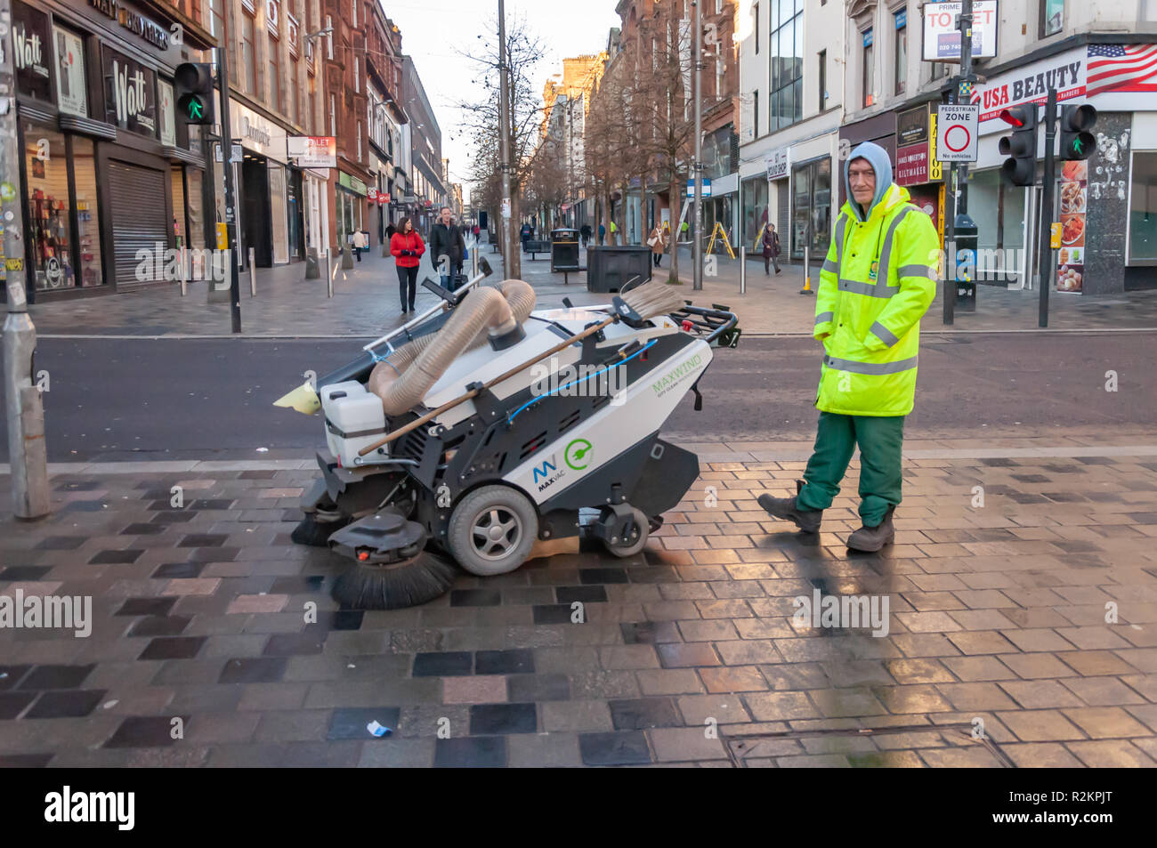 A male Council street cleaner wearing a Hi Vis Jacket and a hoodie ...