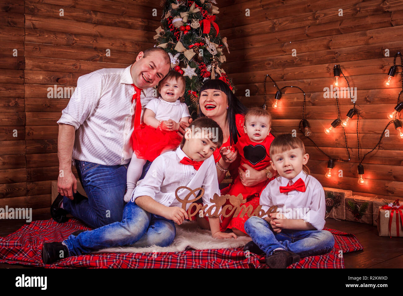 Family gathered around christmas tree hi-res stock photography and ...