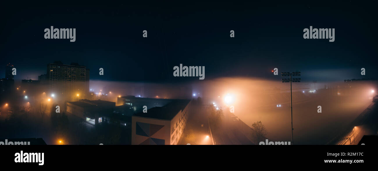 Fog night panorama with lot of street light, football stadium and dark ...