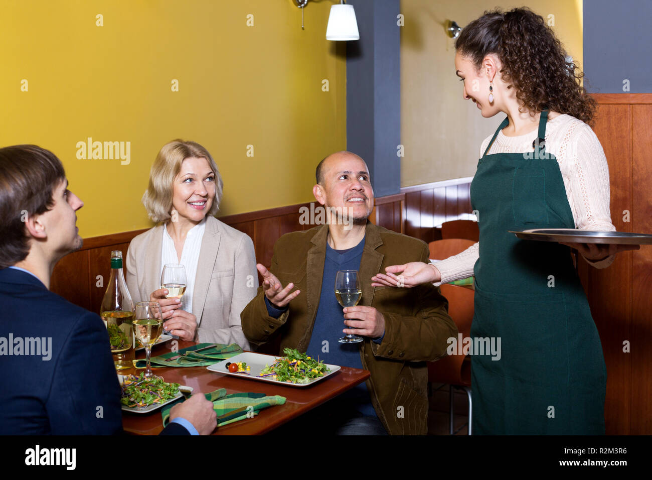 Cheerful middle class people enjoying food, waitress taking order Stock ...
