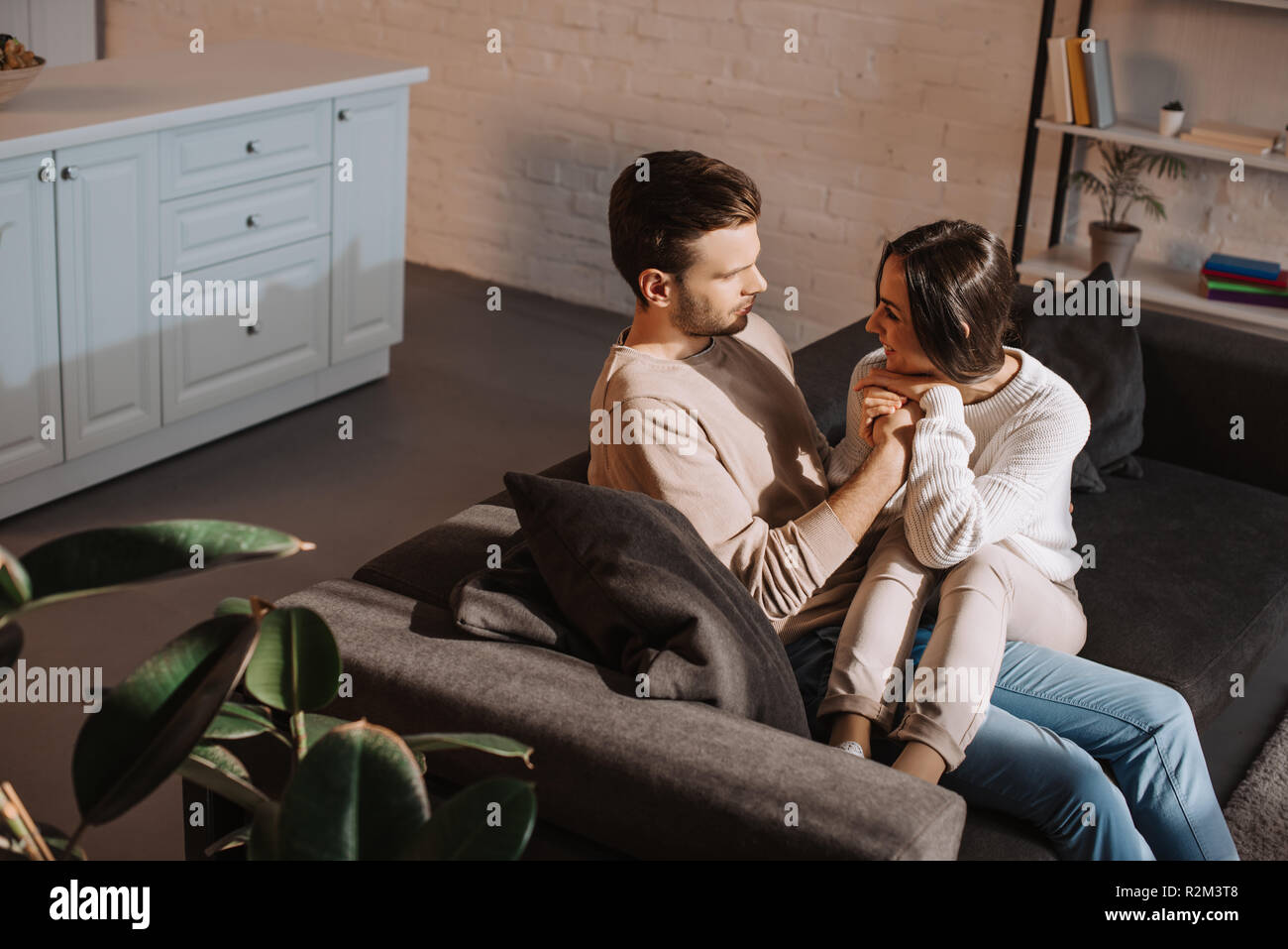 romantic young couple chatting while relaxing on couch at home Stock ...
