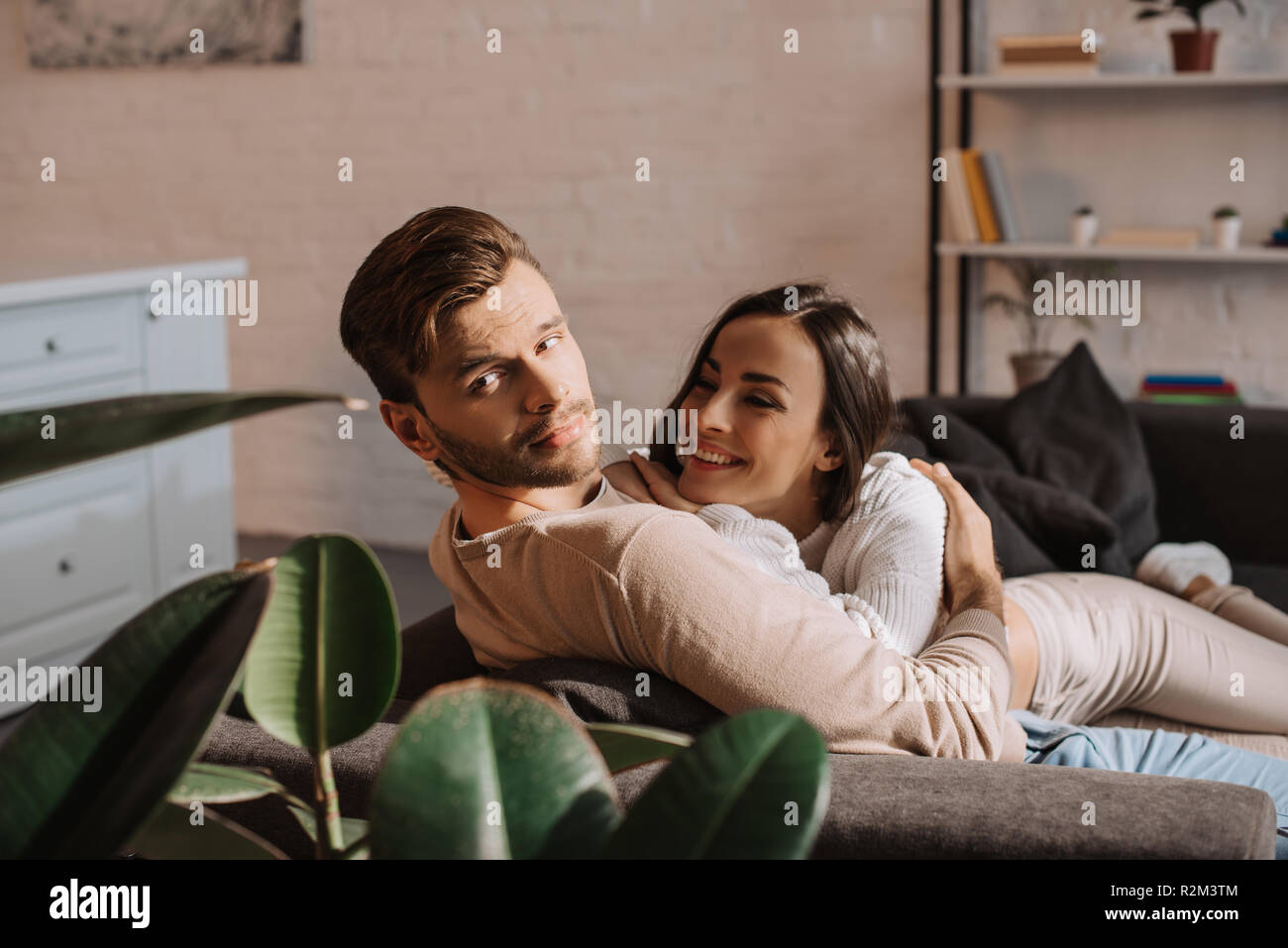 happy romantic young couple flirting on couch at home Stock Photo - Alamy