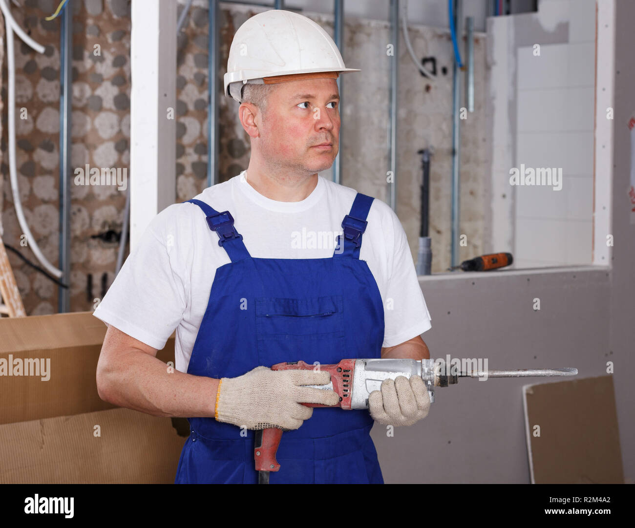 Confident male contractor holding electric perforator ready for ...