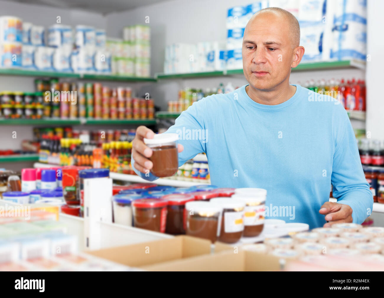 Positive male customer buying food products in supermarket Stock Photo ...