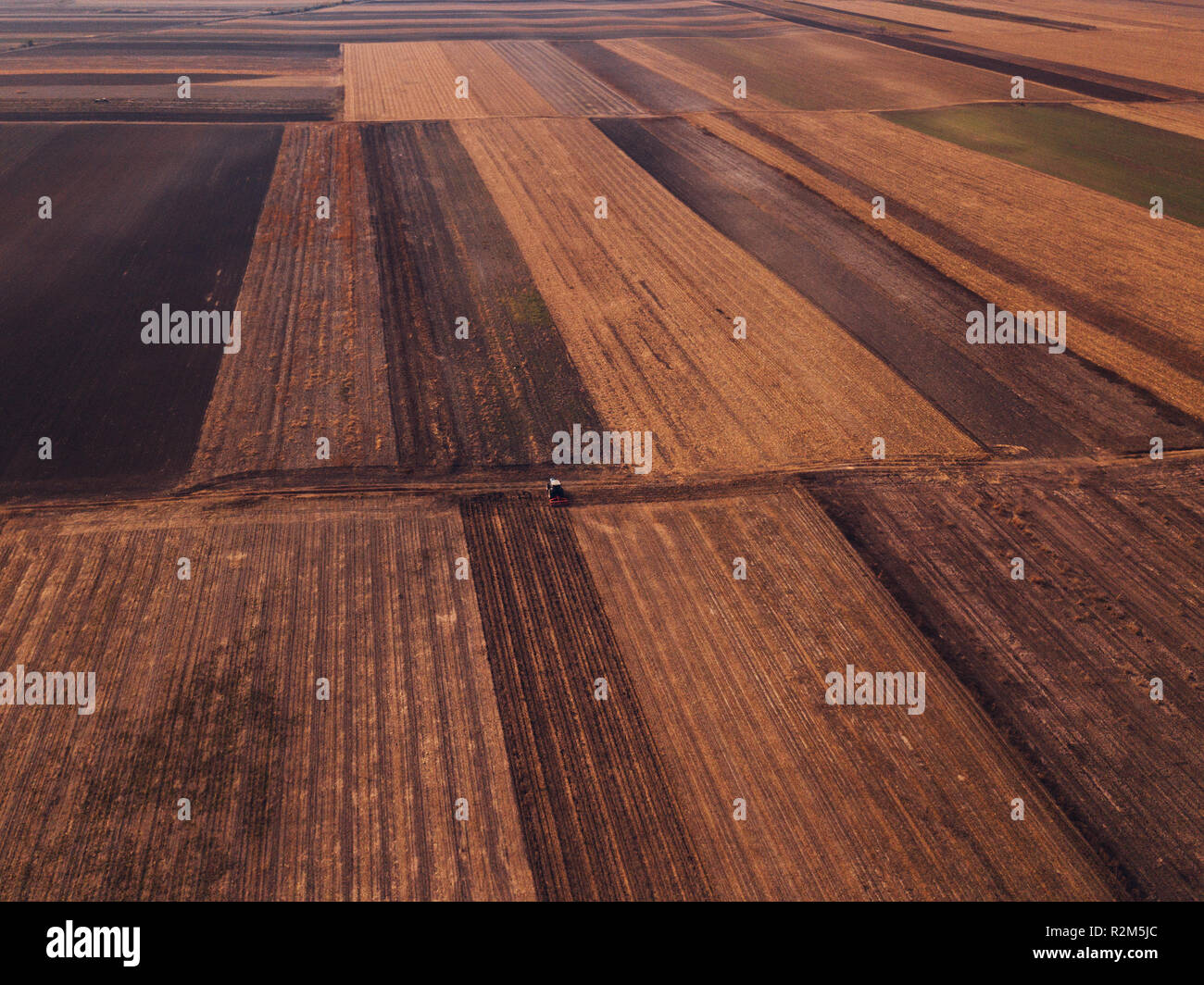 Aerial view of agricultural tractor doing stubble tillage in the field ...
