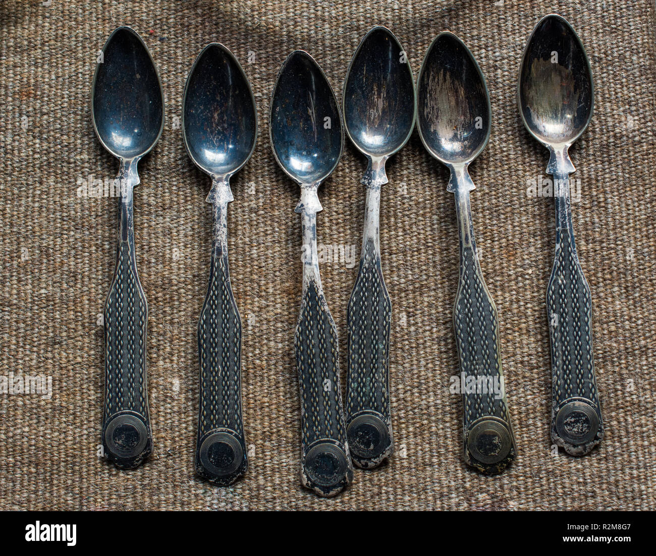 Stylish steel teaspoons on a textured background in display Stock Photo ...