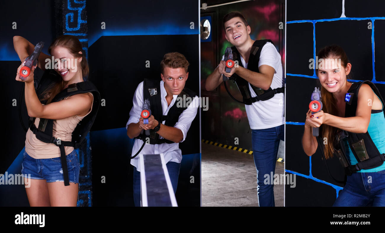 Group of young positive people playing emotionally laser tag game in ...