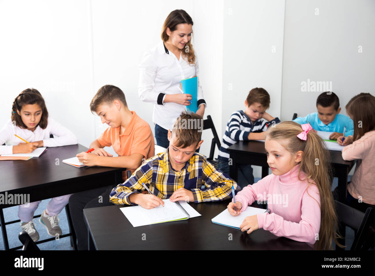 Positive professor and elementary age children at classroom Stock Photo ...